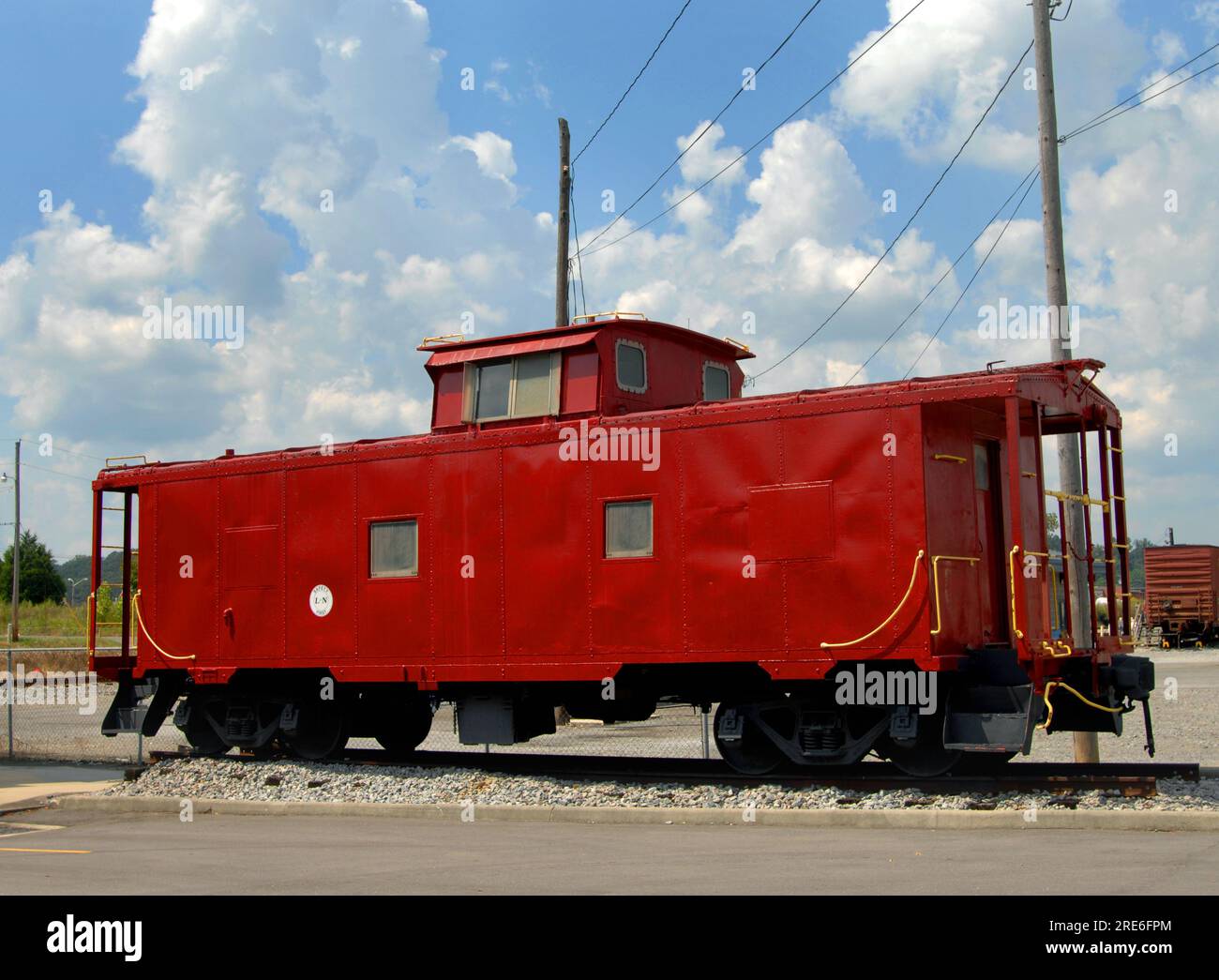 Red caboose sits on cut-off track in a railroad yard in Alabama. Sky is ...