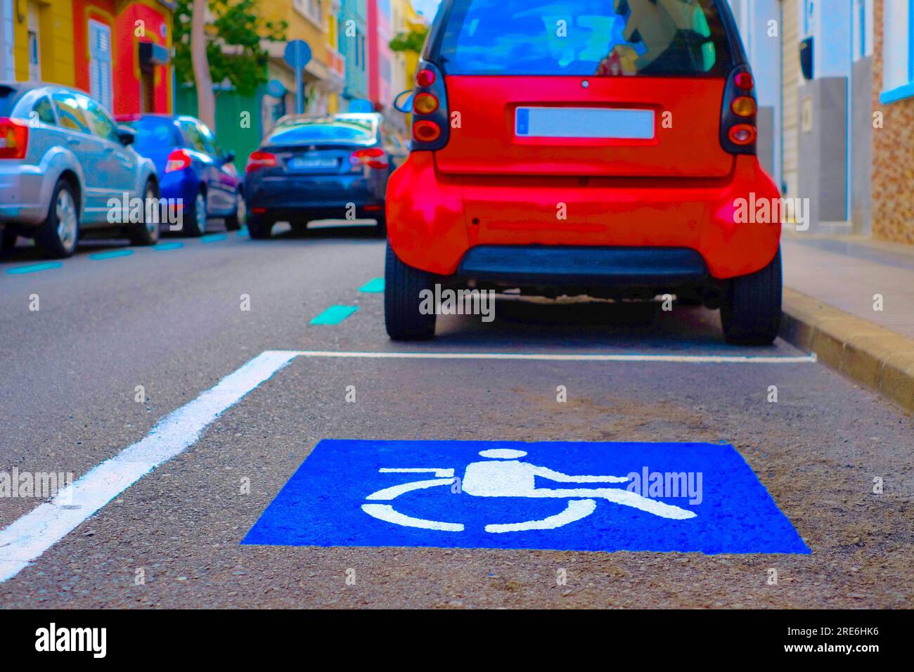 A small car parked correctly next to a parking lot with an ...