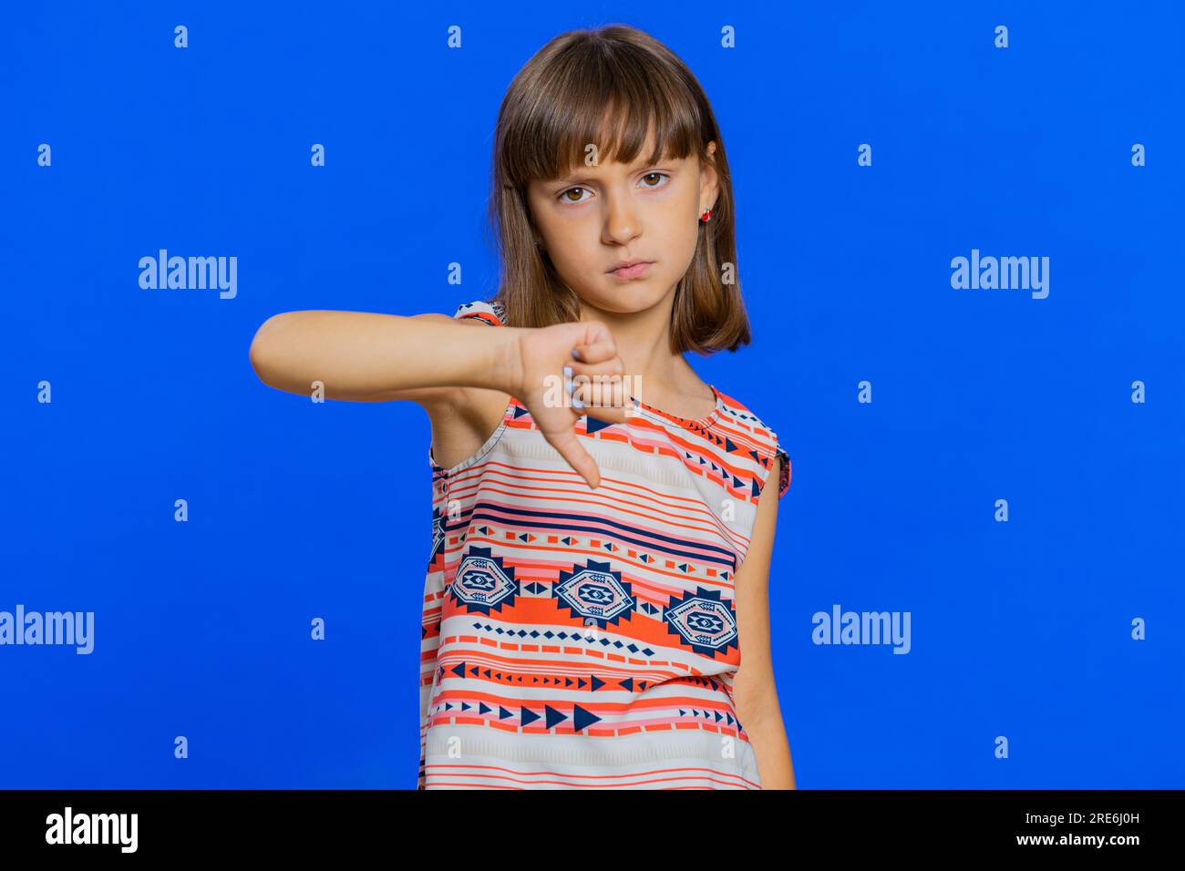 Dislike. Upset young preteen child girl kid showing thumbs down sign ...