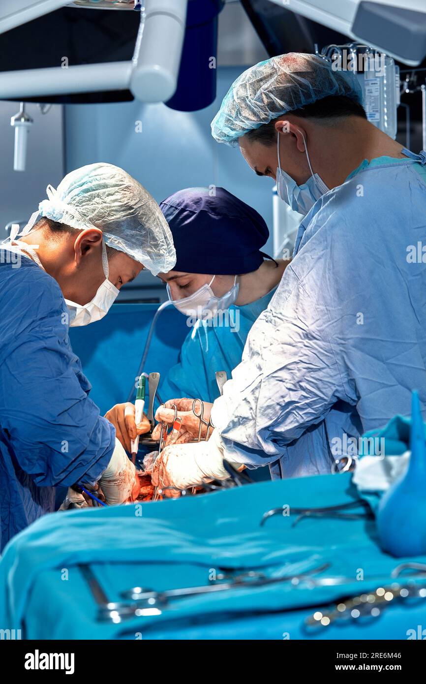 Surgeons team during complex surgical operation in a sterile operating ...