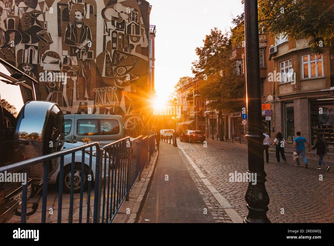 sun sets down an old town street in Plovdiv, Bulgaria. Featuring a ...