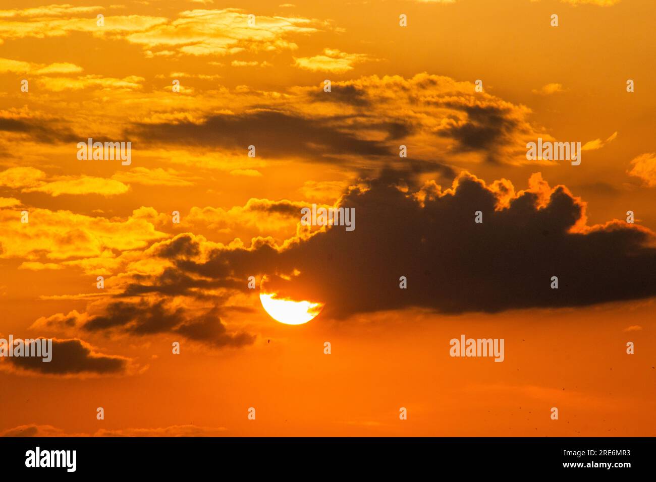 Sky with sun behind a cloud Stock Photo - Alamy