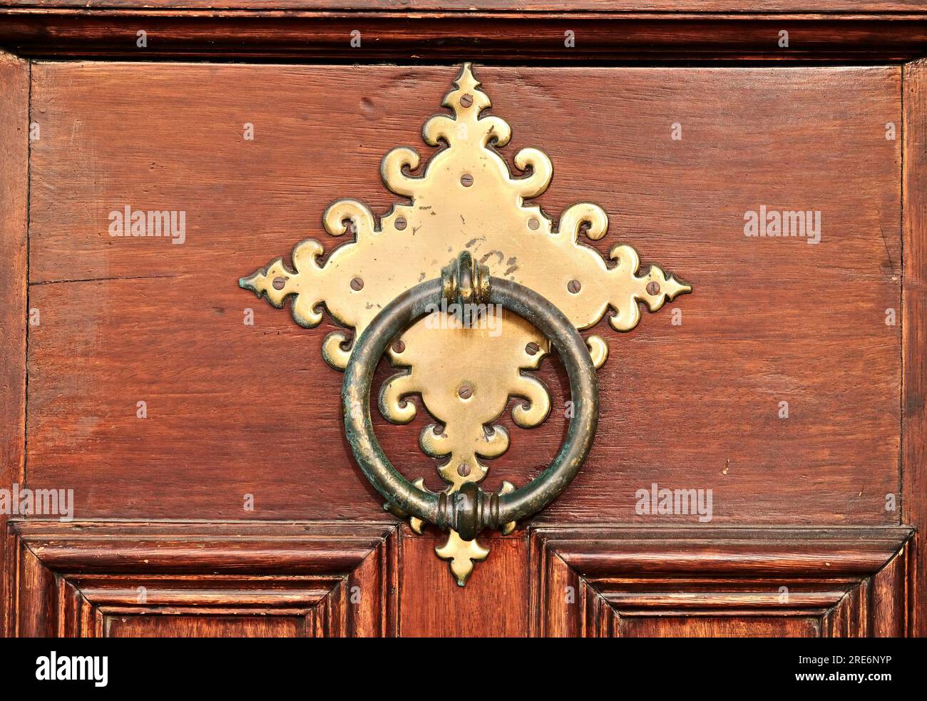 Large round heavy metal door knocker with an ornamental metal plate on ...