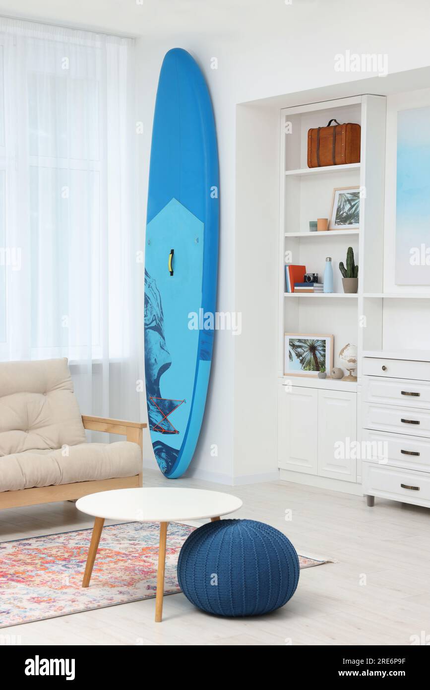SUP board and modern furniture in stylish living room. Interior design ...