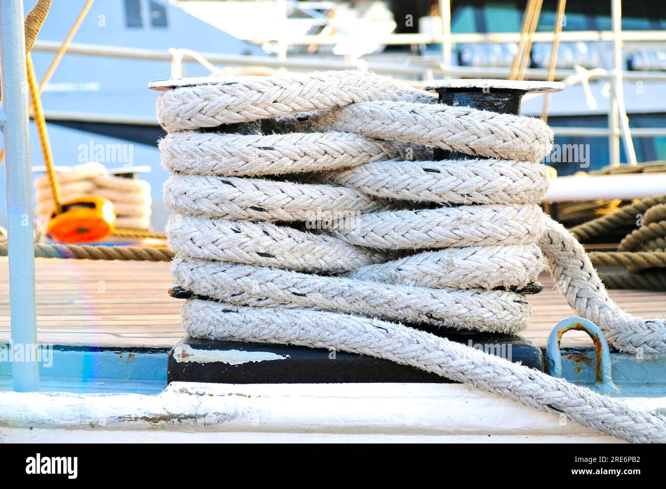 Deck detail of a classic sailing ship, cleat with belayed docking line ...