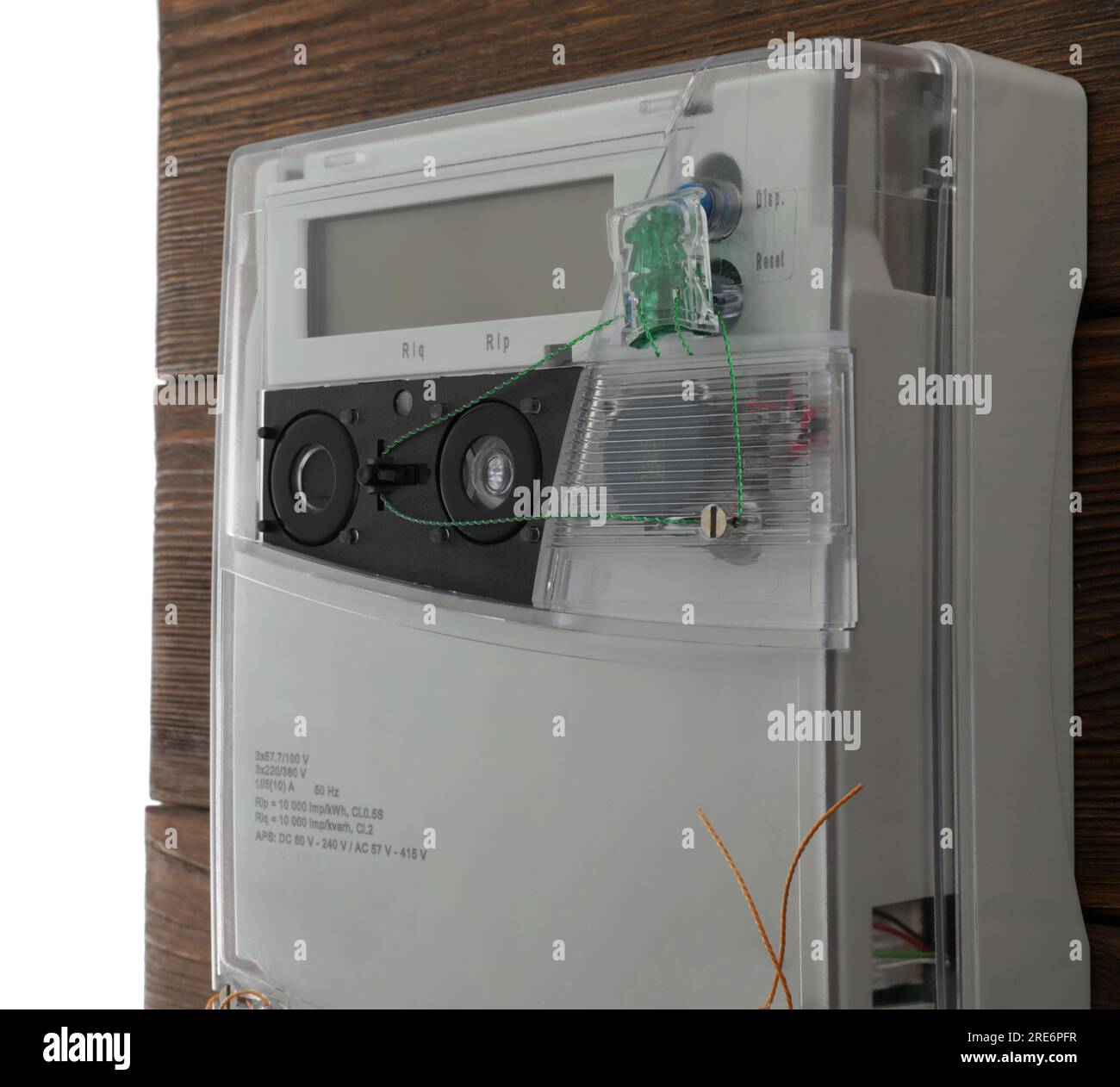 Electricity meter on wooden wall against white background, closeup ...