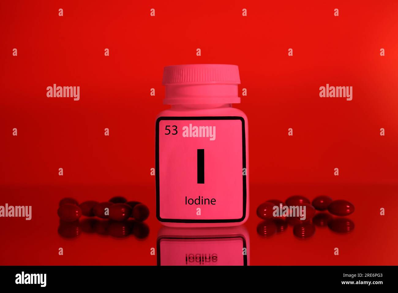 Bottle of medical iodine and pills on red background, color tone effect ...