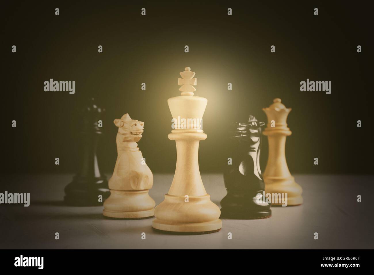 Different chess pieces on grey table against dark background Stock ...