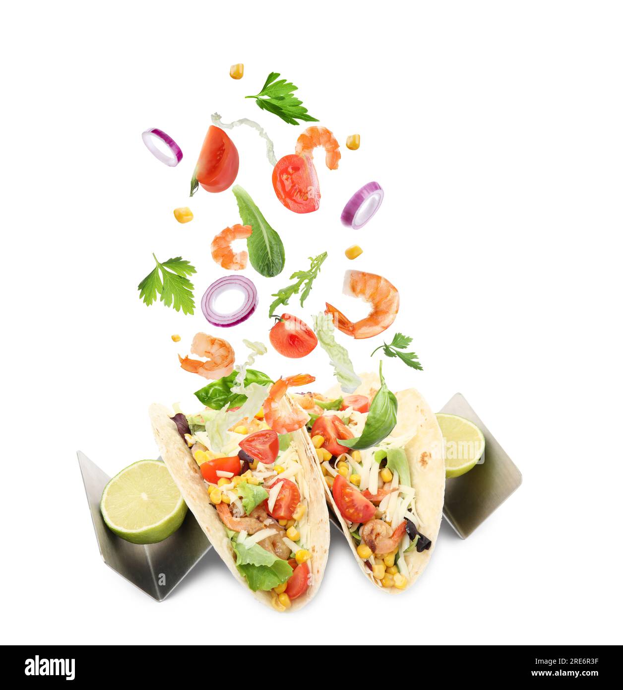 Delicious tacos. Ingredients falling into tortillas on white background ...