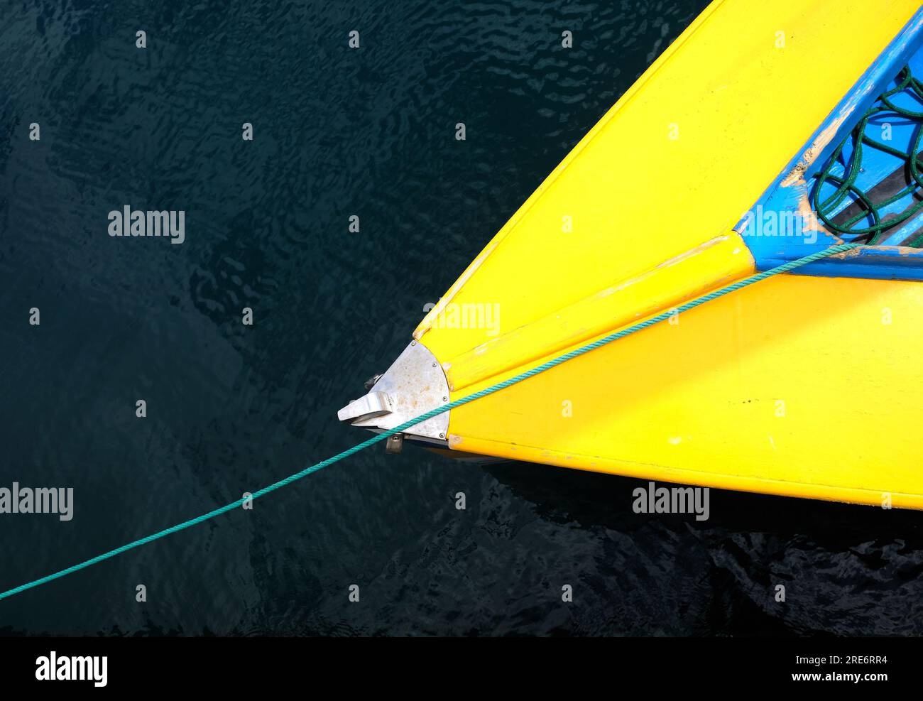 Bow detail of a simple wooden boat with bright blue cockpit. Top view ...
