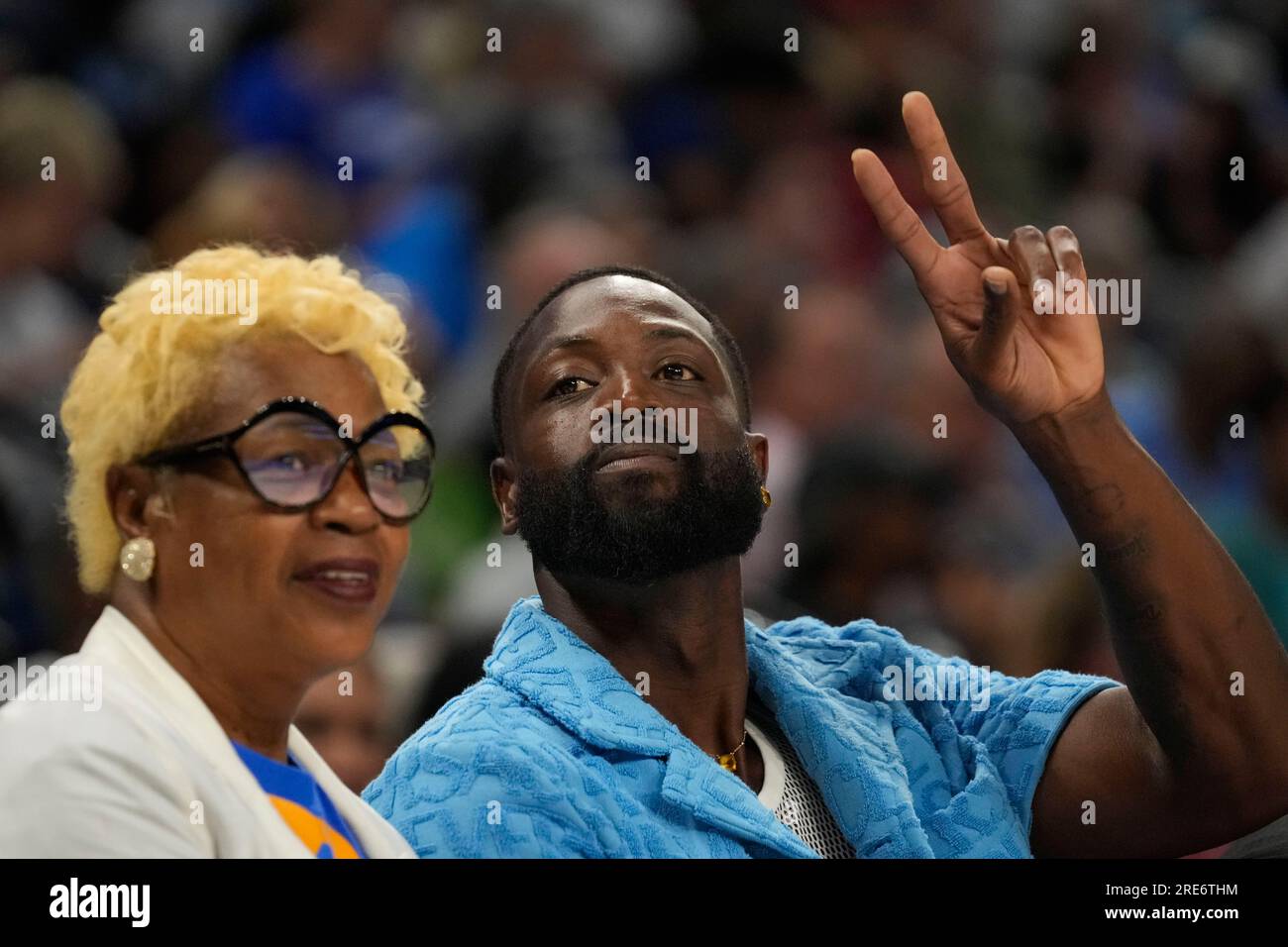 Former NBA player Dwayne Wade flashes a peace sign during the second ...