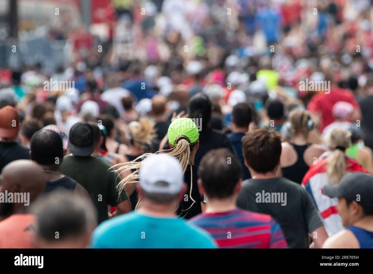 A lone green neon hat stands out in a massive crowd of runners ...