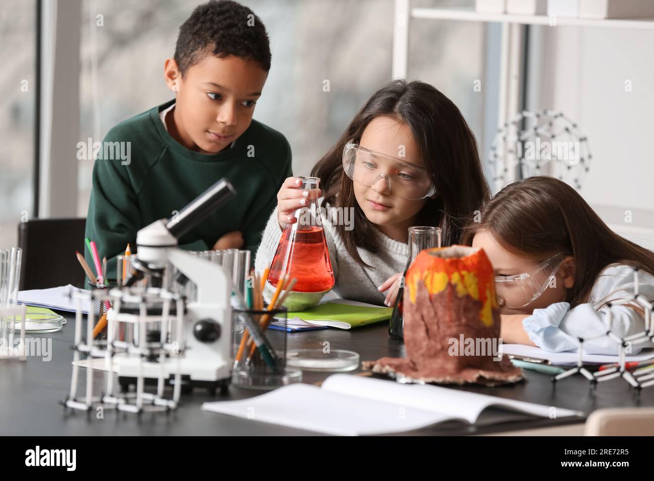 Little children conducting chemistry experiment in science classroom ...
