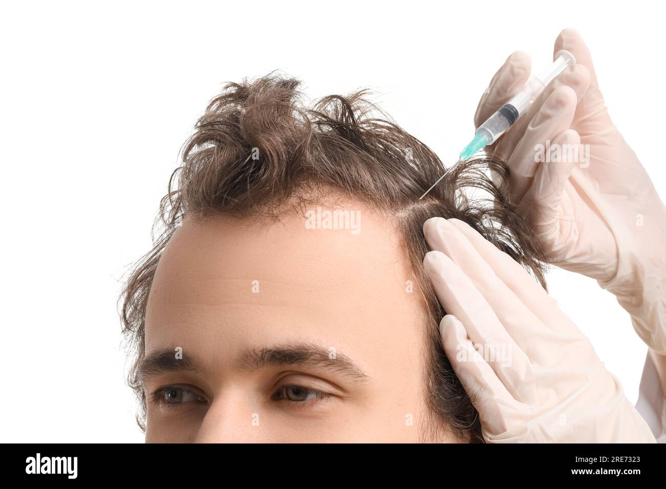 Young man receiving injection for hair growth on white background ...