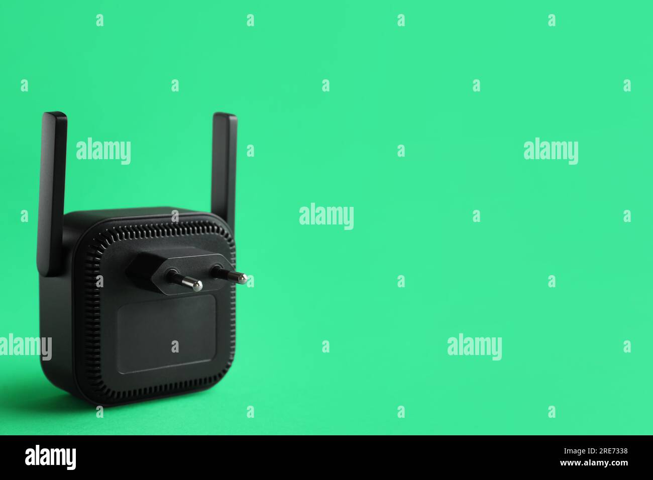 Black WiFi repeater on green background Stock Photo - Alamy