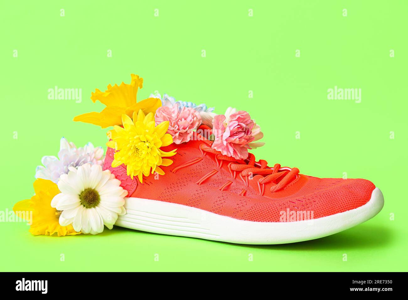 Sneaker with spring flowers on green background Stock Photo - Alamy