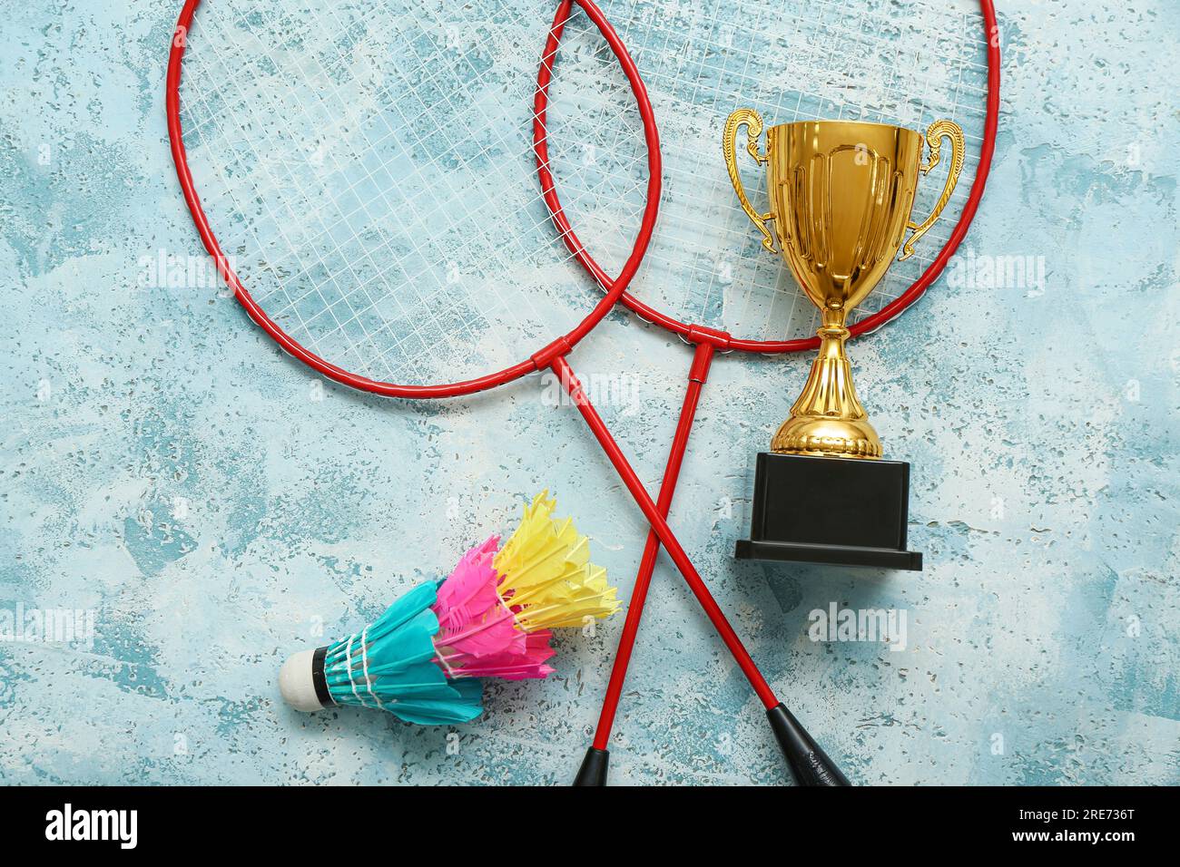 Gold cup with badminton rackets and shuttlecocks on grunge background ...