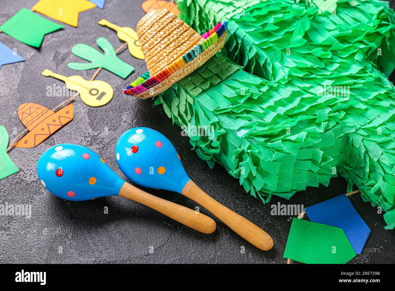 Mexican maracas with sombrero hat, pinata and garland on dark ...