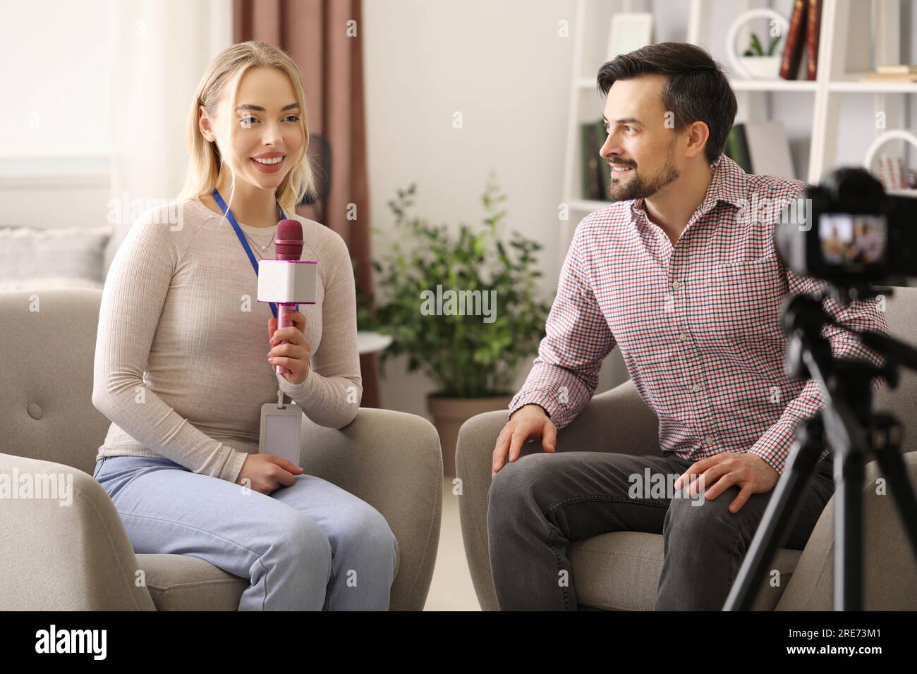 Female journalist with microphone having an interview with man in ...