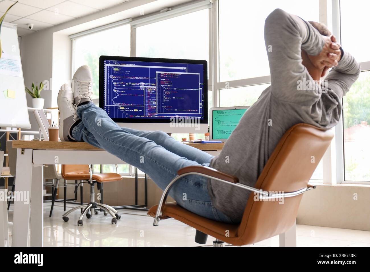 Mature male programmer sitting in light office at his workplace Stock ...
