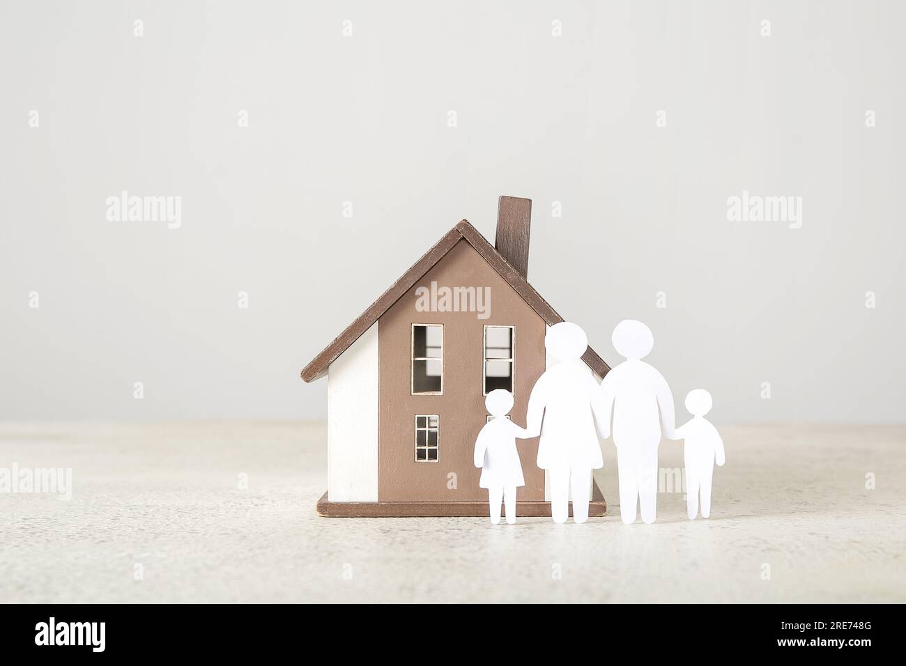 Figures of family with house on light background Stock Photo - Alamy