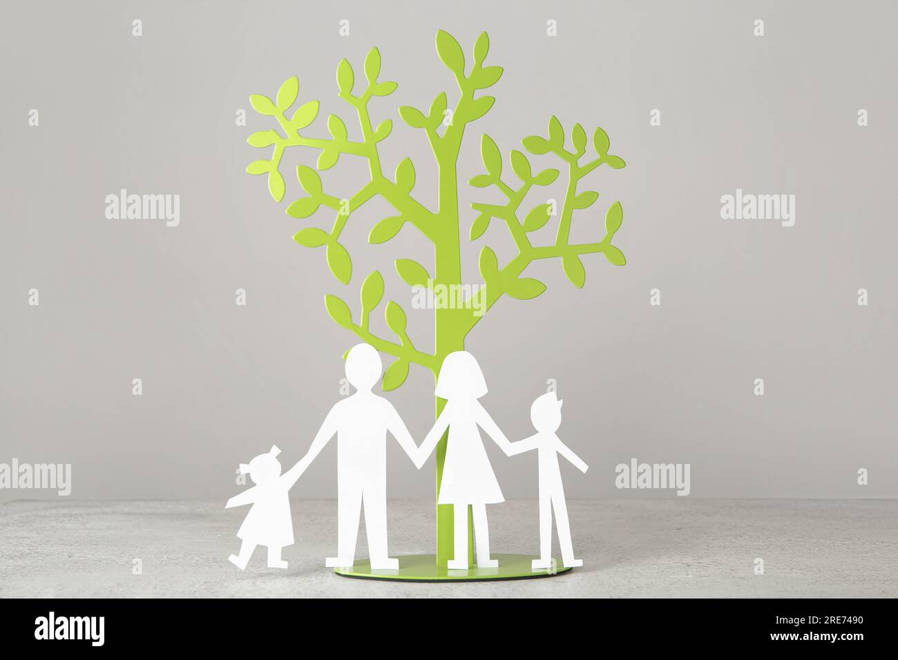 Figures of family with decorative tree on white table Stock Photo - Alamy