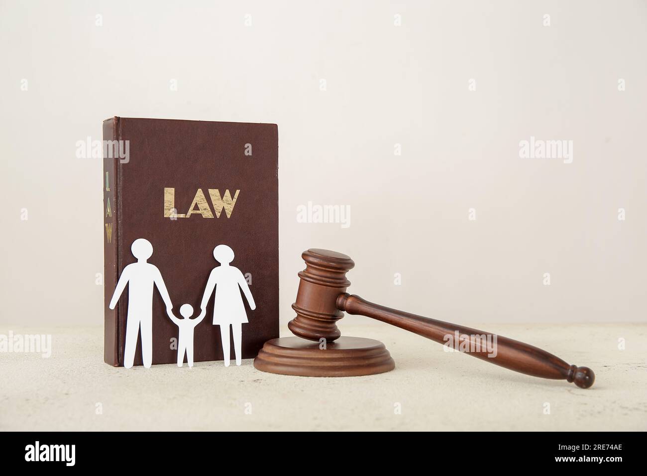 Figures of family with judge's gavel and law book on grunge white table ...