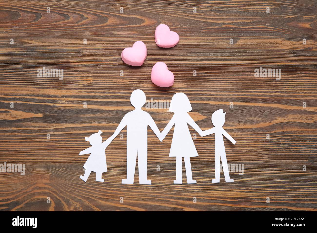 Figures of family and hearts on brown wooden background Stock Photo - Alamy