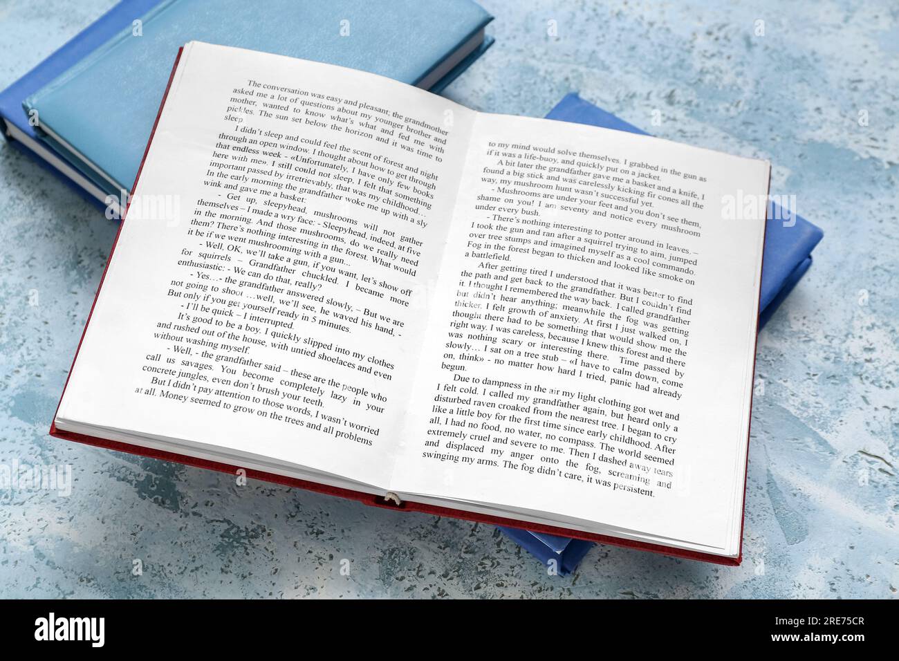 Open book on light blue table Stock Photo - Alamy