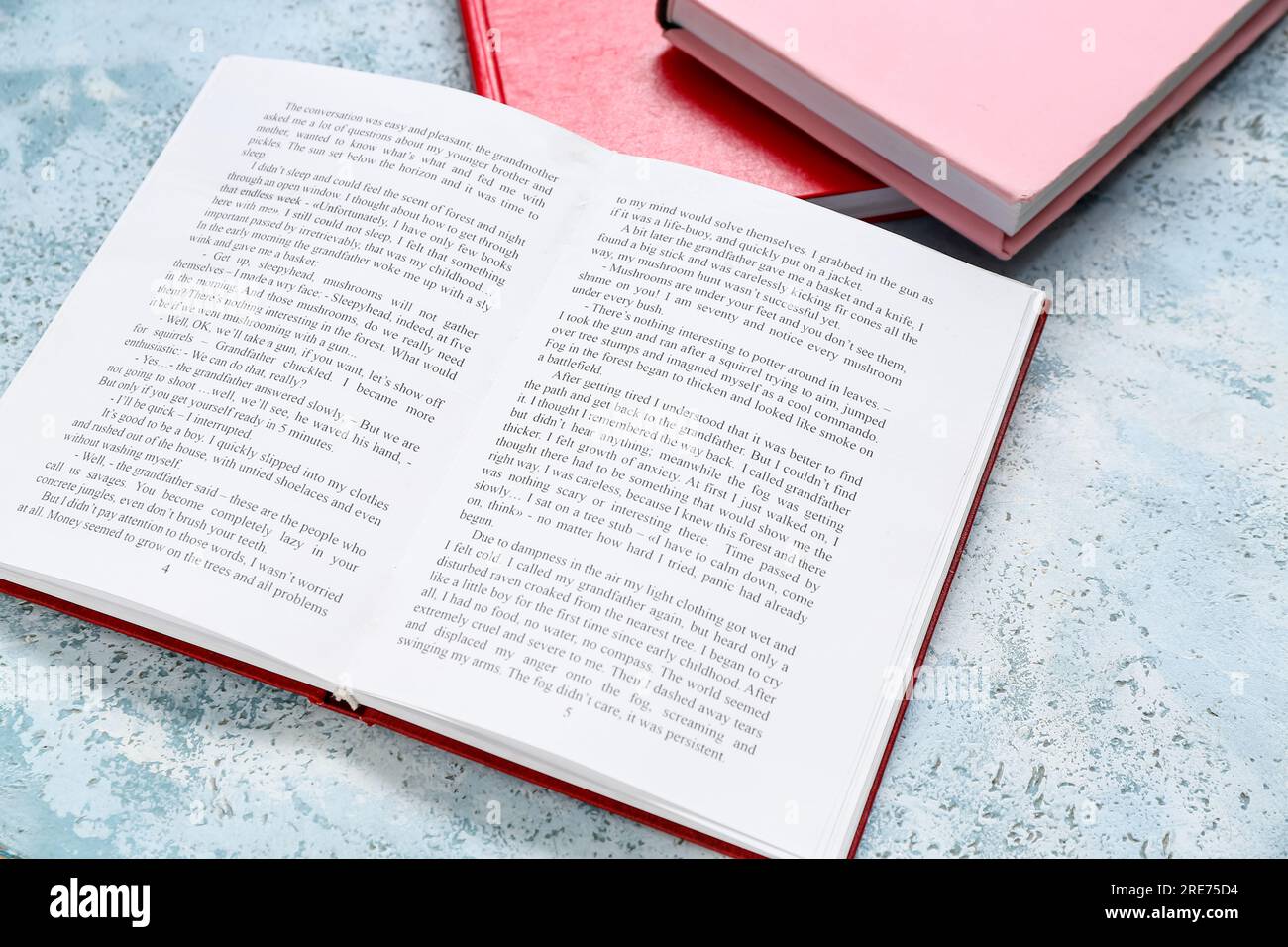 Open book on light blue table Stock Photo - Alamy