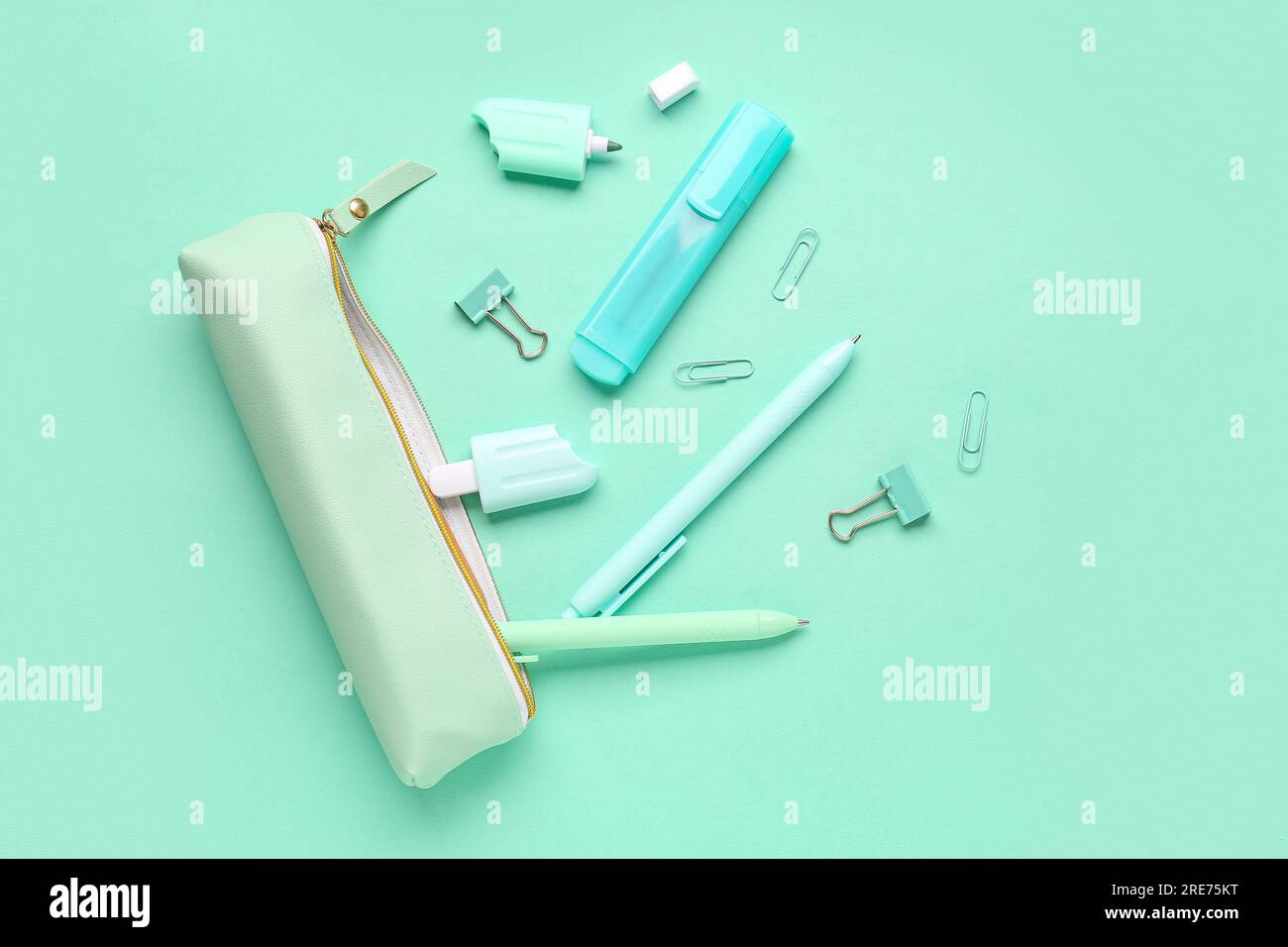 Pencil case with different stationery on turquoise background Stock ...