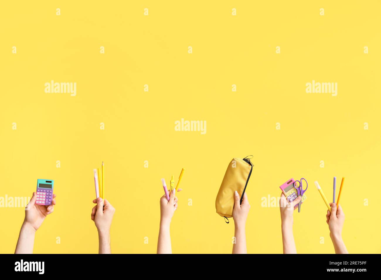 Hands with school supplies on yellow background Stock Photo - Alamy