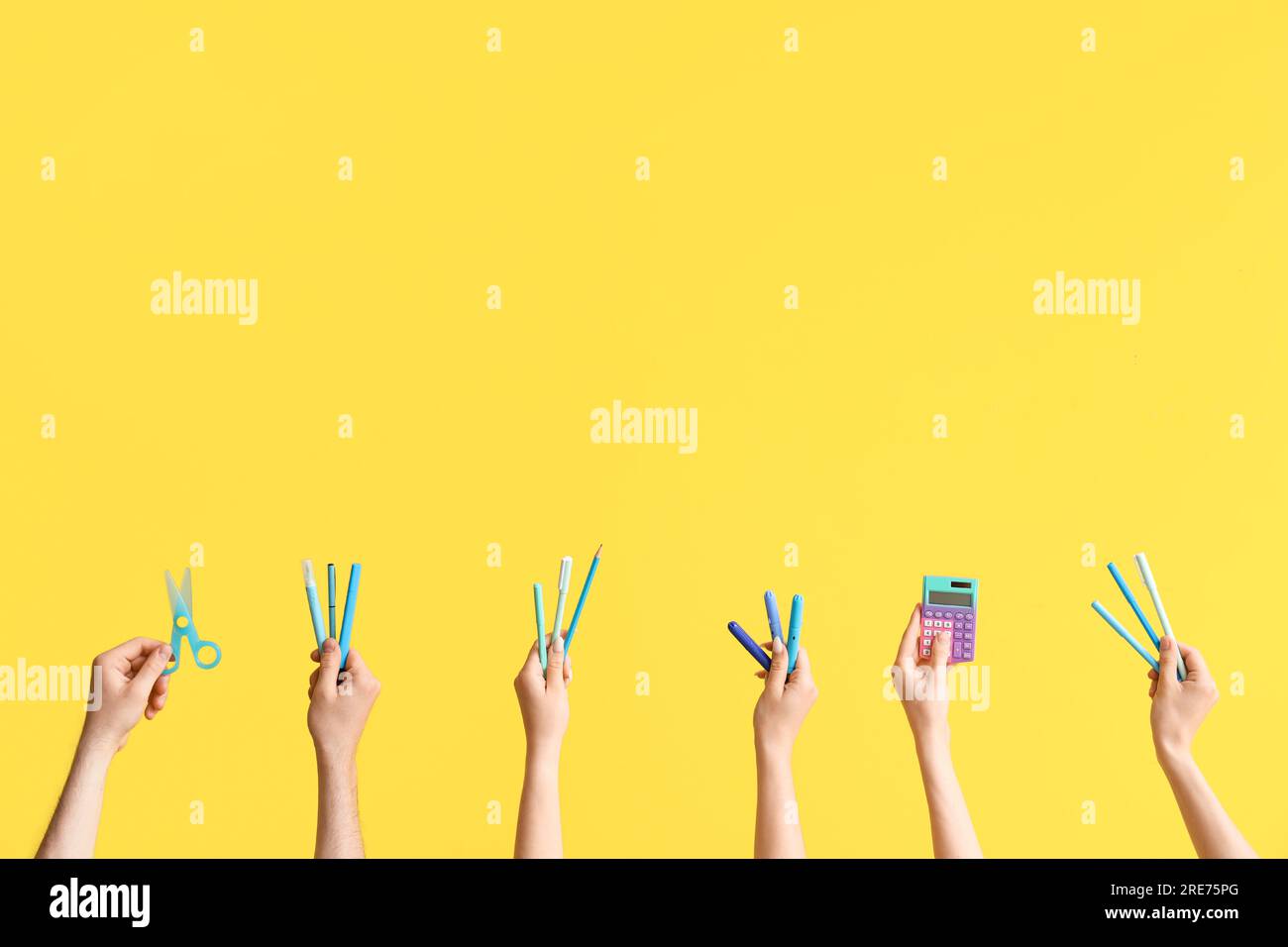 Hands with school supplies on yellow background Stock Photo - Alamy