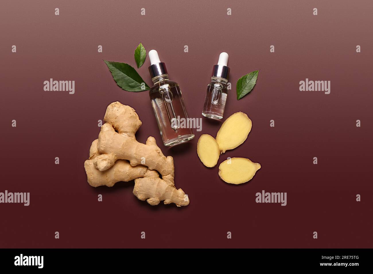 Bottles of ginger cosmetic oil and leaves on brown background Stock ...