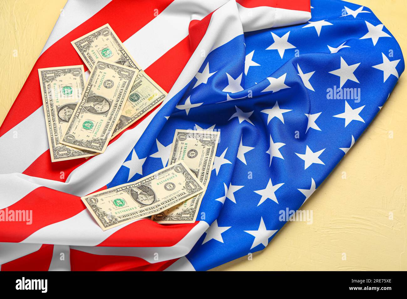 Flag of USA and dollar banknotes on yellow background Stock Photo - Alamy