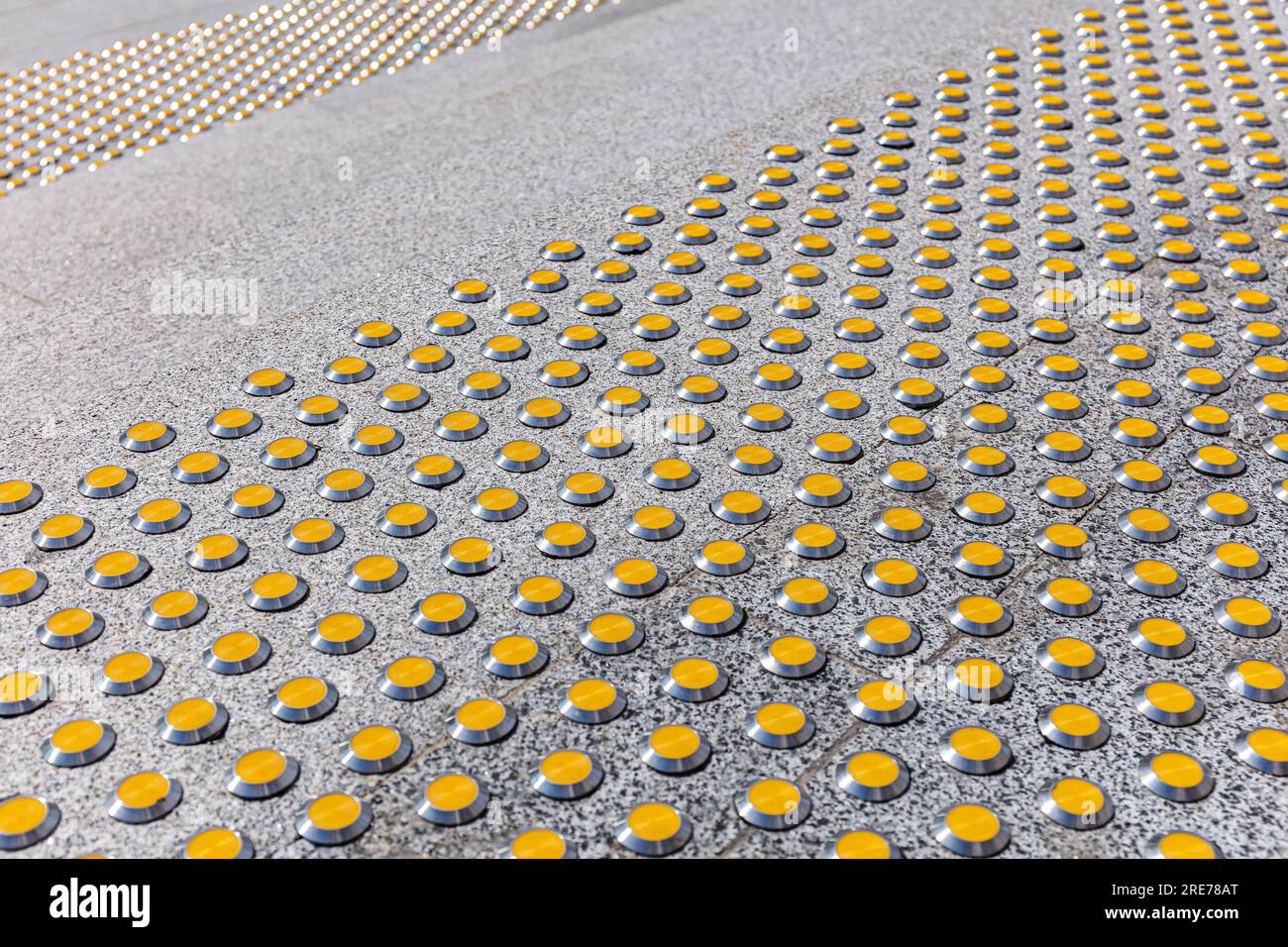 steps of a granite staircase with yellow tactile nonskid markings ...
