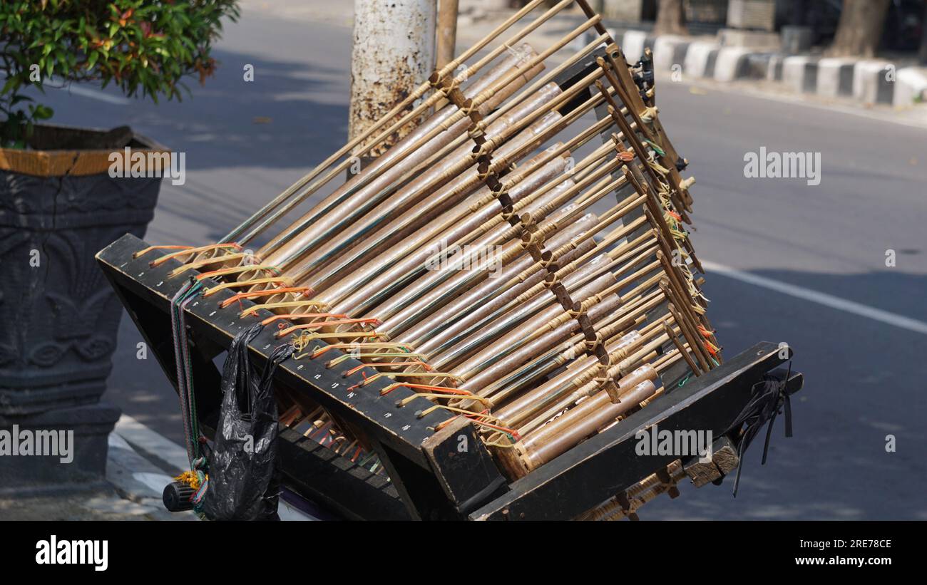 A man is playing angklung. That is a multitonal musical instrument that ...