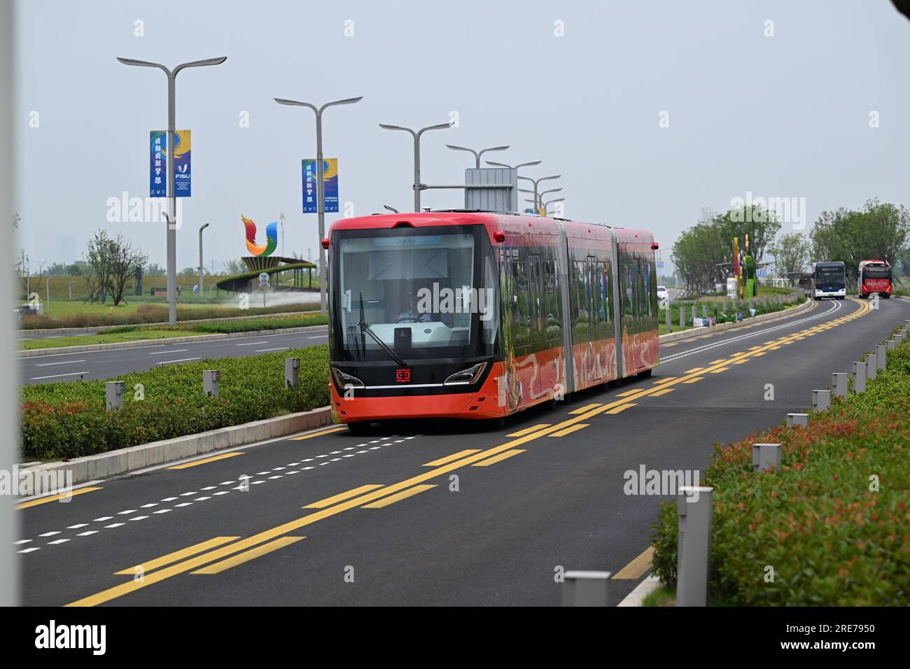 Two autonomous rail buses travel on the road in Chengdu City, southwest ...