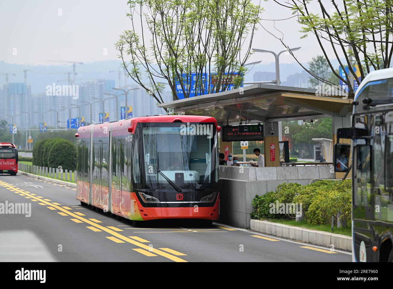 Two autonomous rail buses travel on the road in Chengdu City, southwest ...