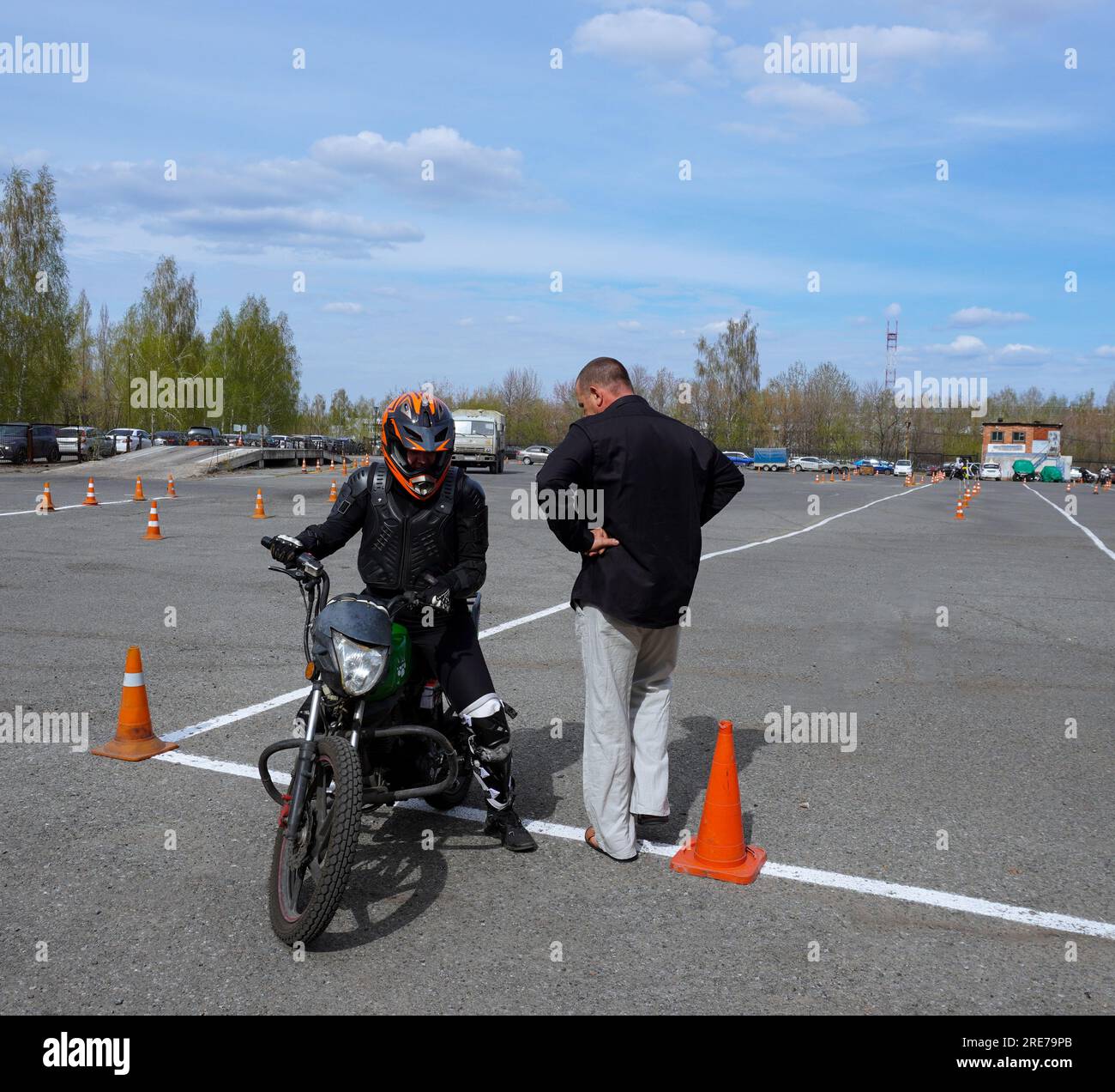A young woman is learning to ride a motorbike in a motorcycle school ...