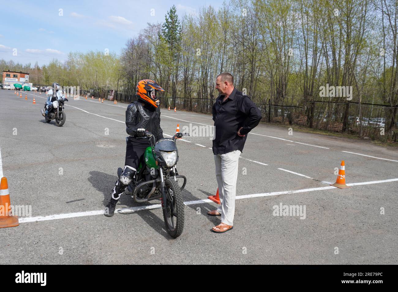 A young woman is learning to ride a motorbike in a motorcycle school ...
