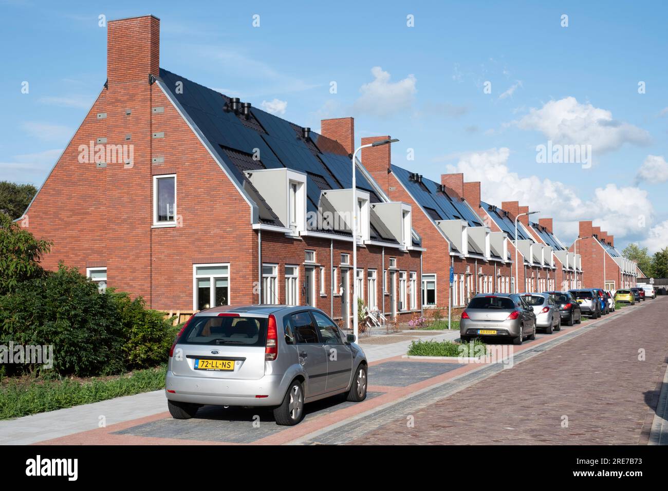 Street with modern social single-family new-build homes with solar ...