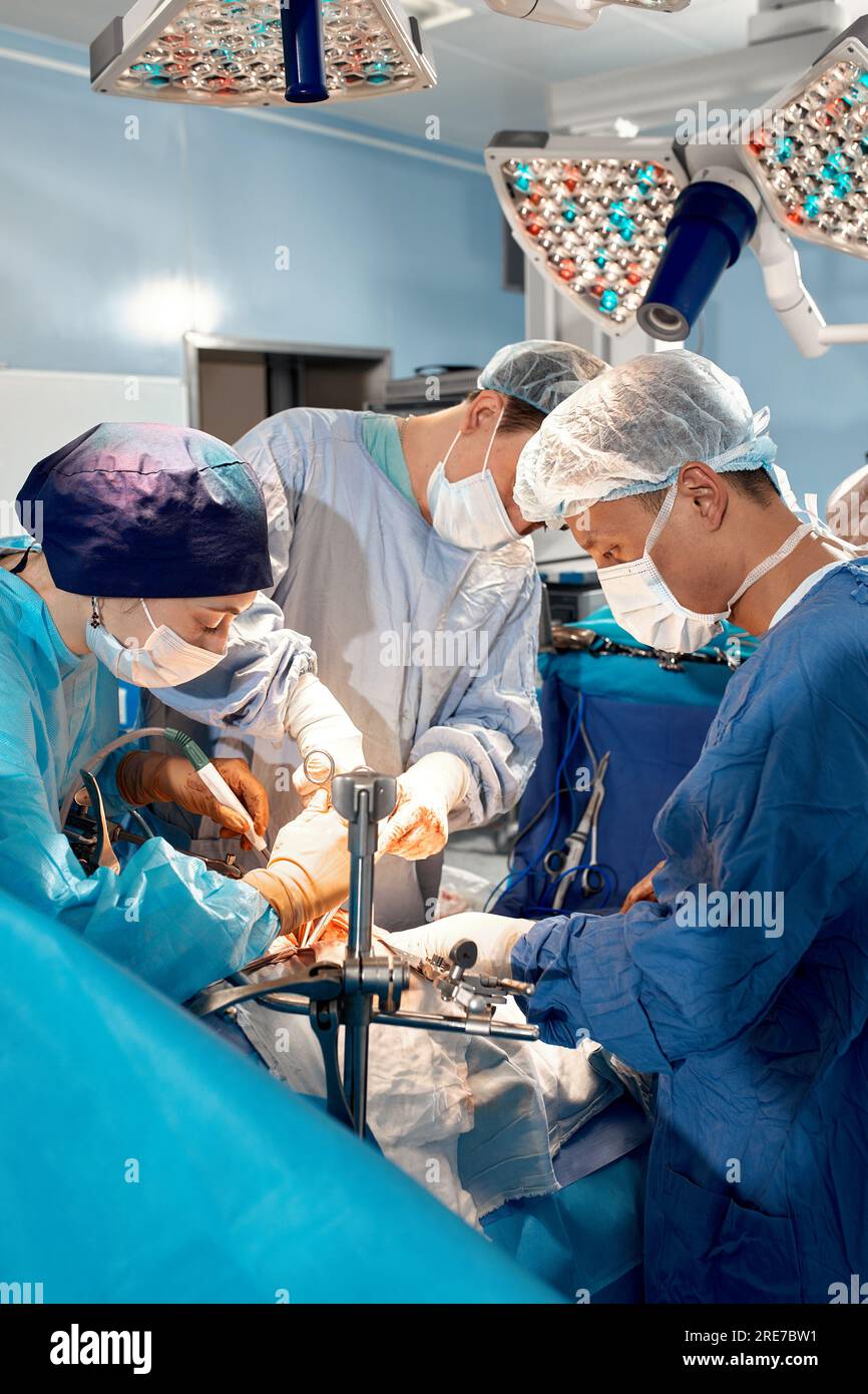 Surgeons team during complex surgical operation in a sterile operating ...