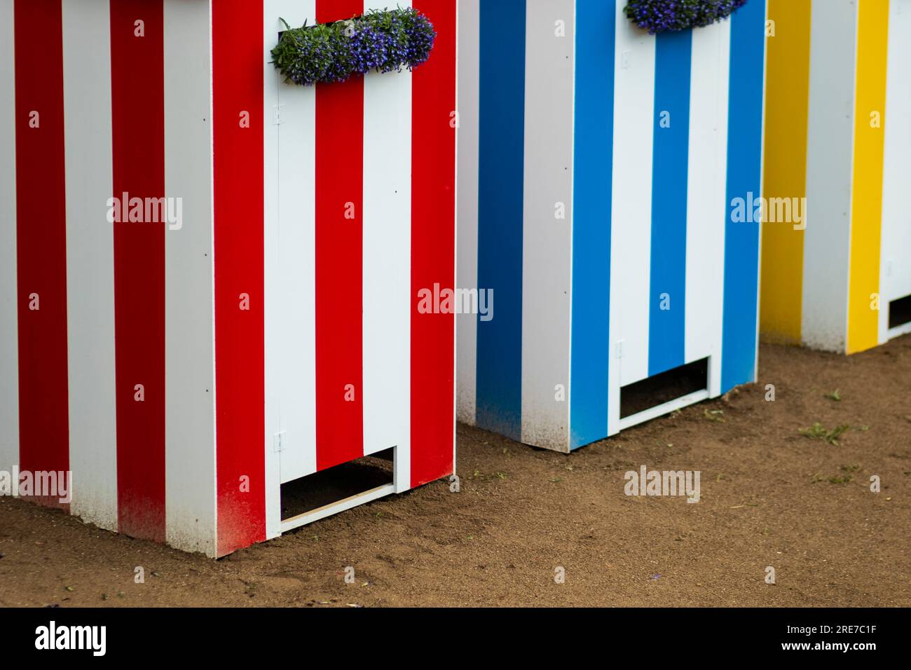Colorful striped huts in a row in a beach scene Stock Photo - Alamy