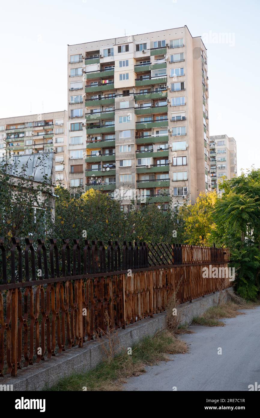 an extremely rusted wrought iron fence and high rise apartment block in ...