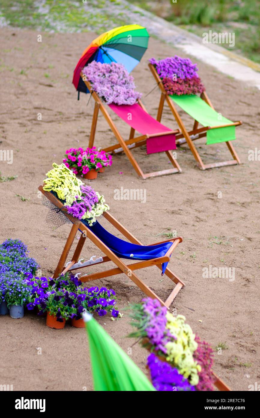 Beach seats on a sand beach decorated with some flowers Stock Photo - Alamy