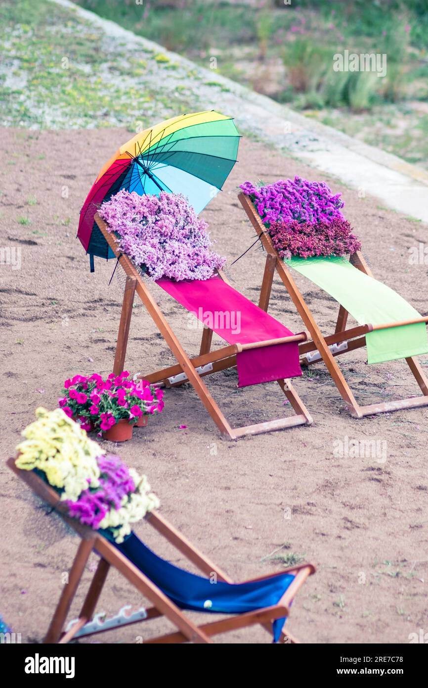 Beach seats on a sand beach decorated with some flowers Stock Photo - Alamy