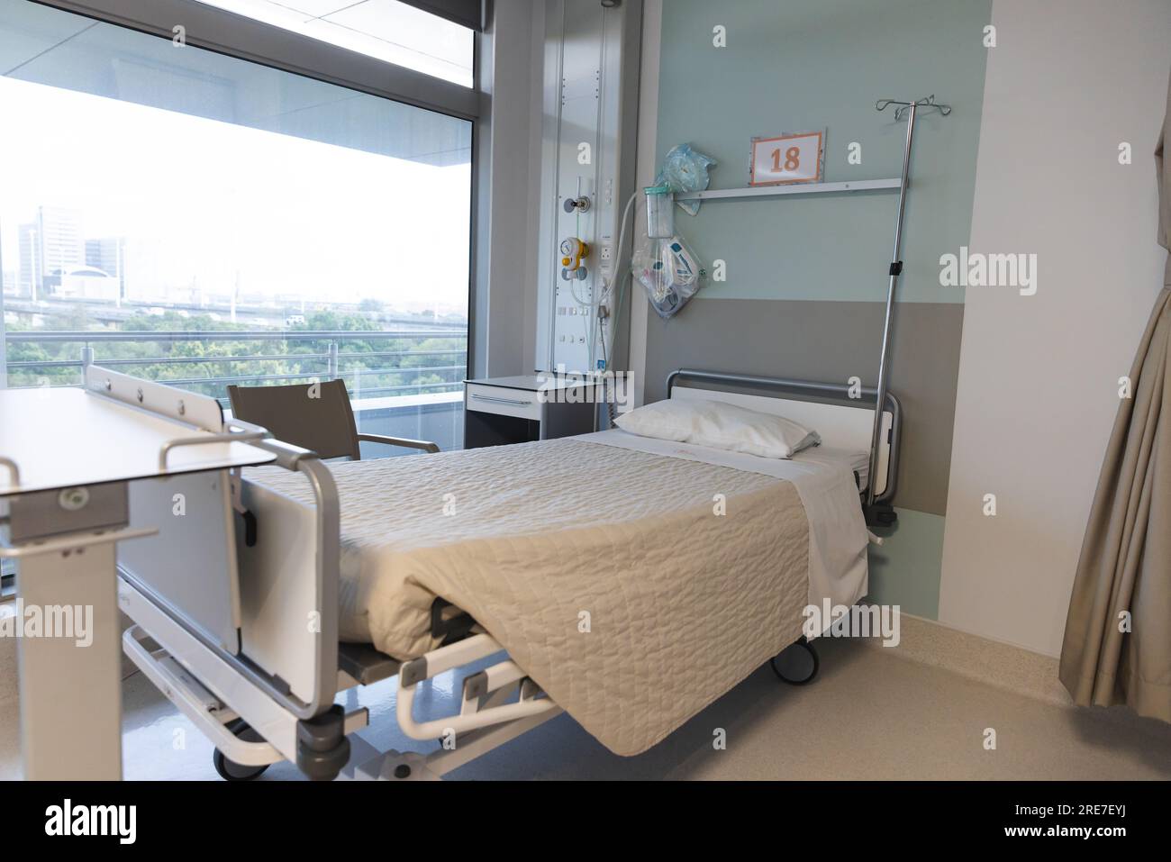 General view of patient room with bed, medical equipment and window at ...