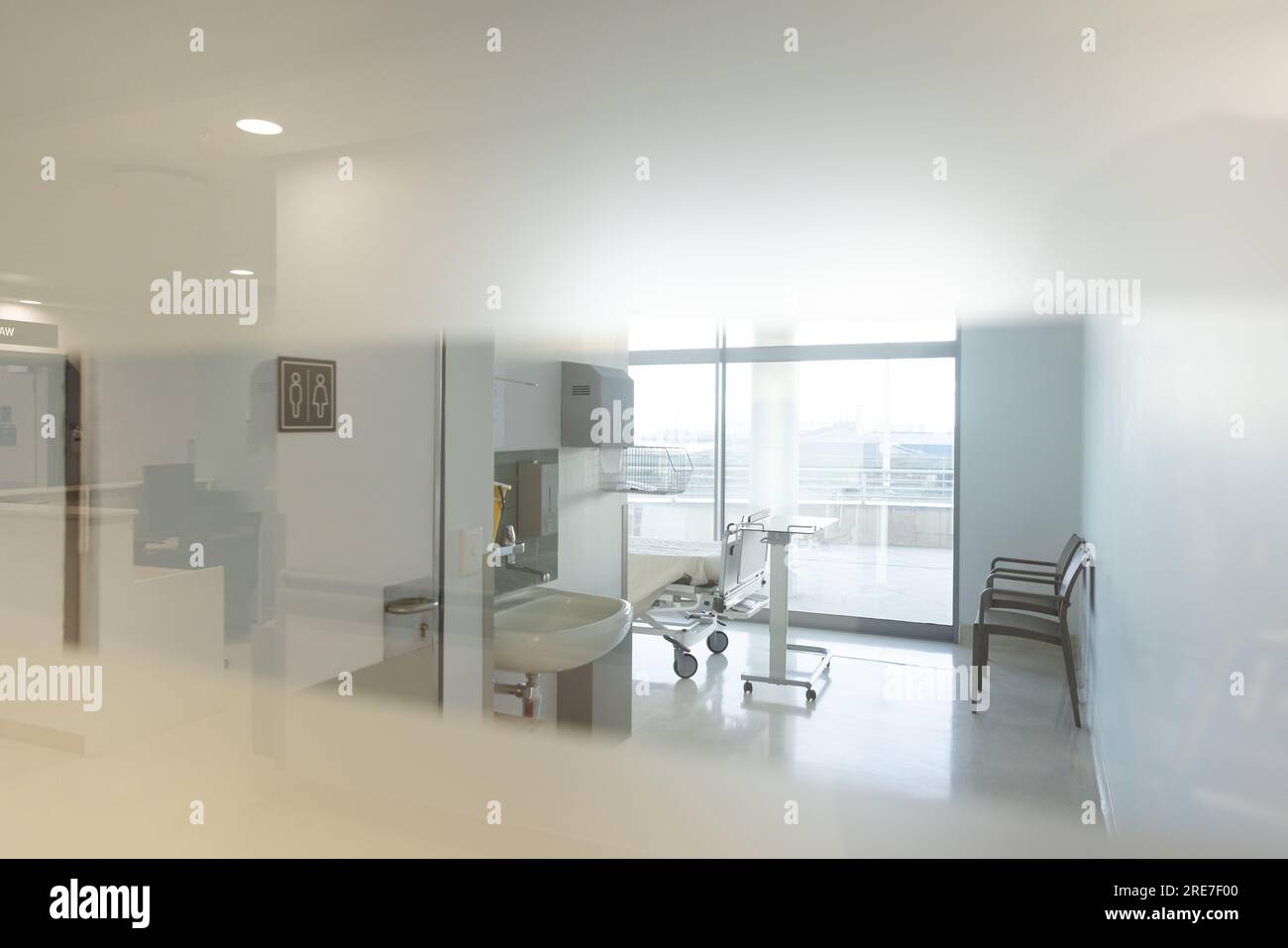 View through door window of patient room with bed and medical equipment ...