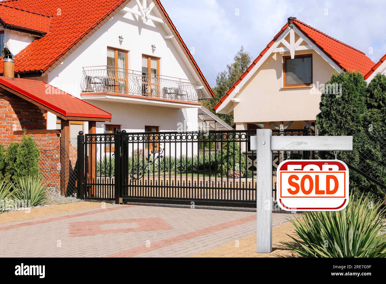 Red sale sign with Sold sticker near house Stock Photo - Alamy